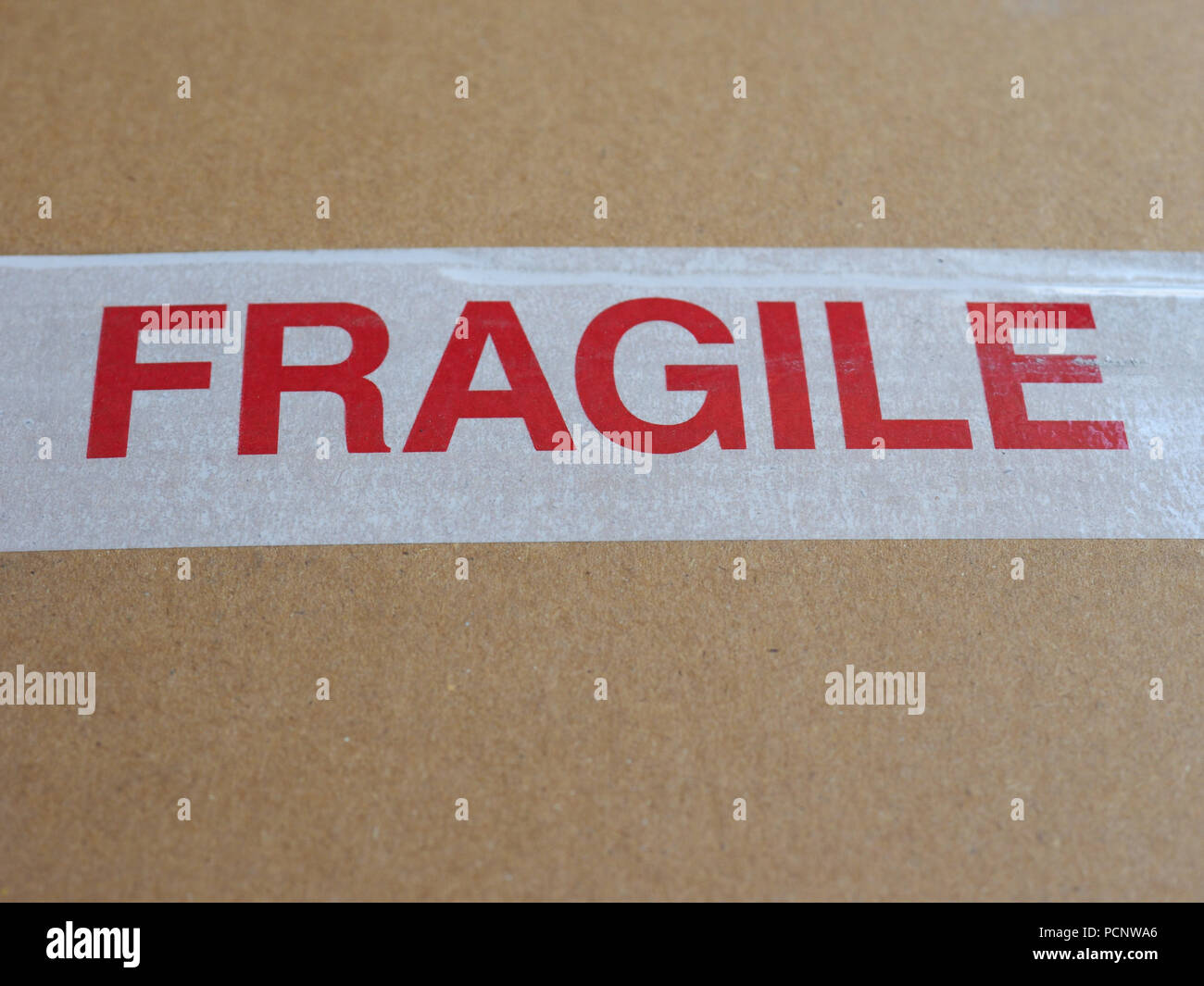 fragile warning tape on brown corrugated cardboard Stock Photo - Alamy
