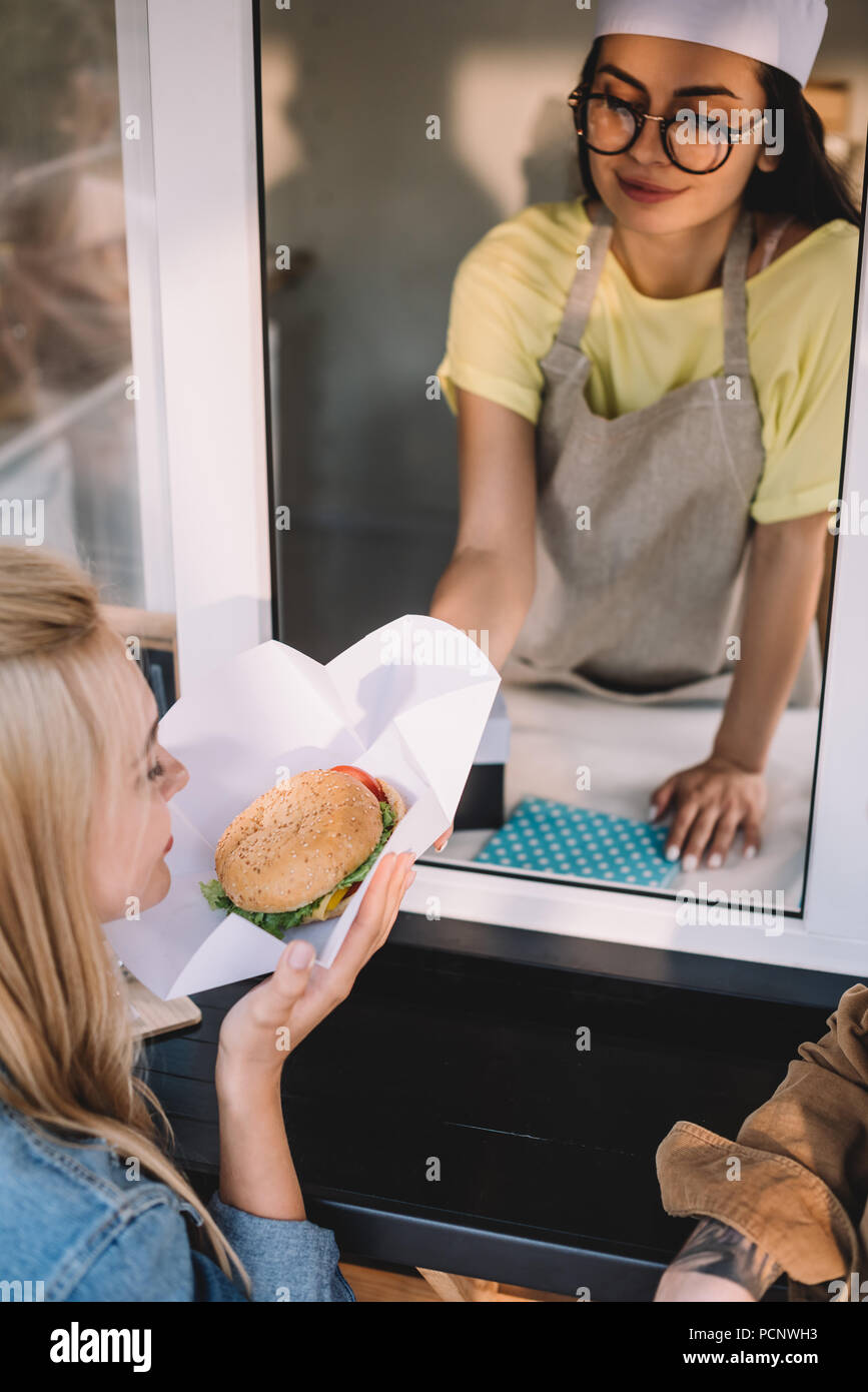 high angle view of chef giving burger to customer in food truck Stock ...