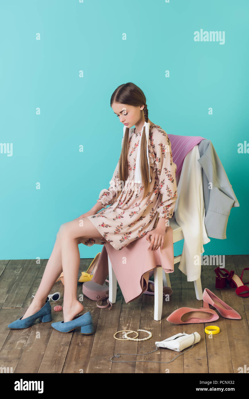 attractive youth girl sitting on chair with mess on floor Stock Photo ...