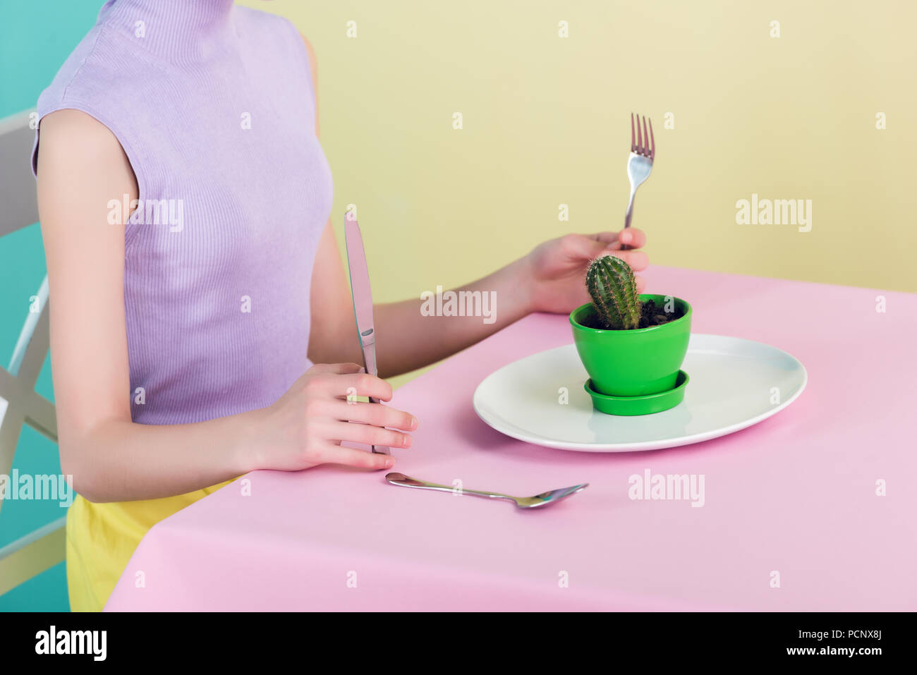 cropped view of teen girl eating cactus with fork and knife, diet ...