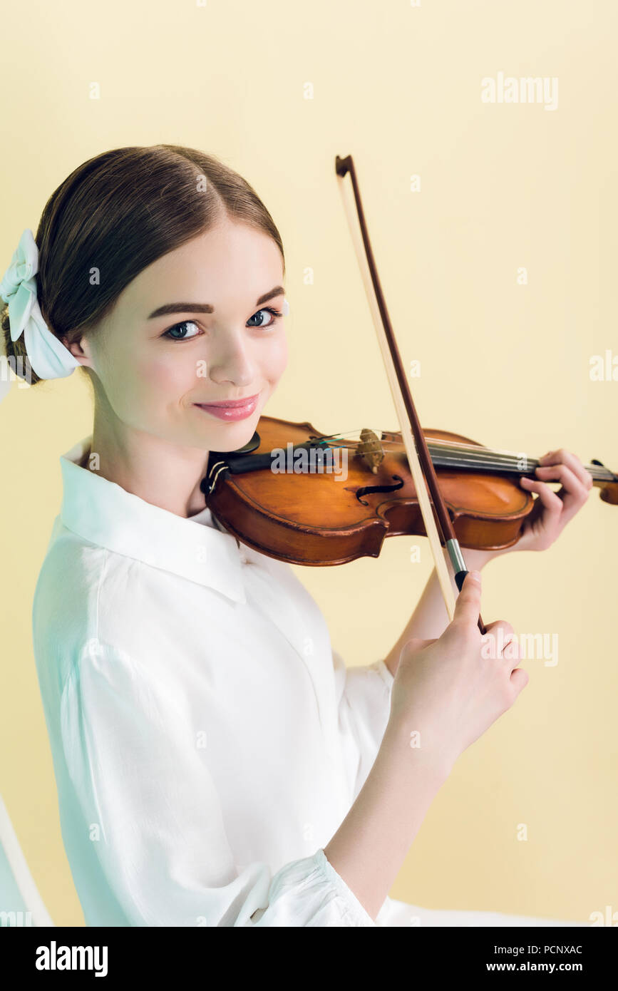attractive teen girl playing violin, isolated on yellow Stock Photo - Alamy