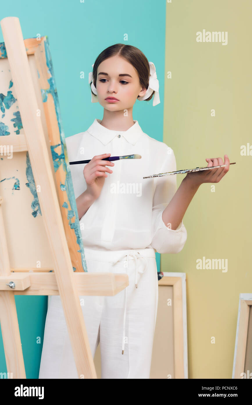 beautiful teen artist painting on easel with brush and palette Stock ...