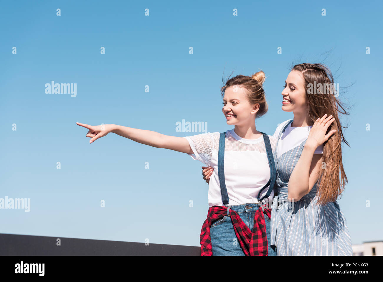 young attractive woman pointing to smiling female friend Stock Photo ...