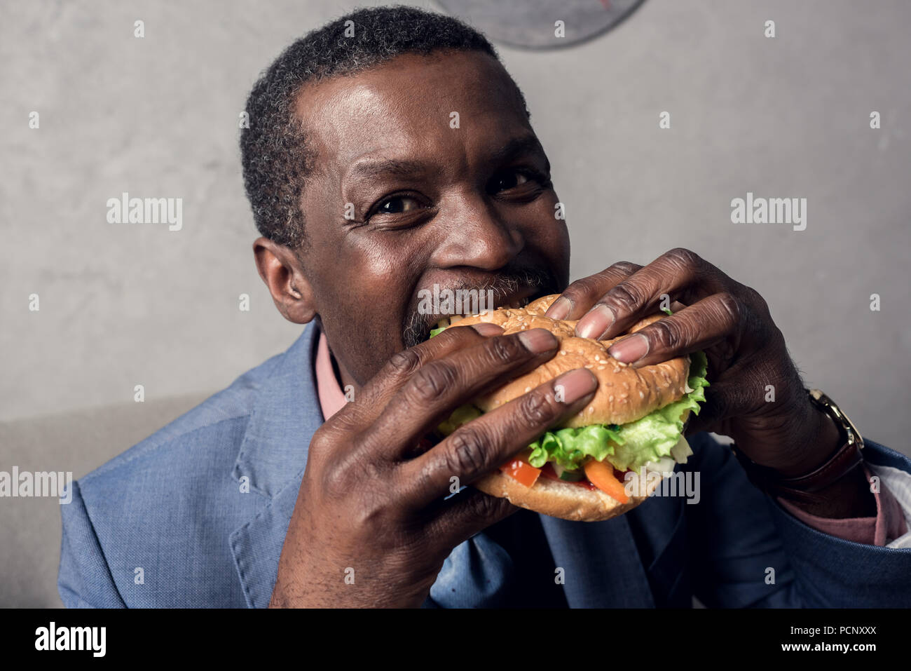 hungry african american man eating hamburger Stock Photo - Alamy