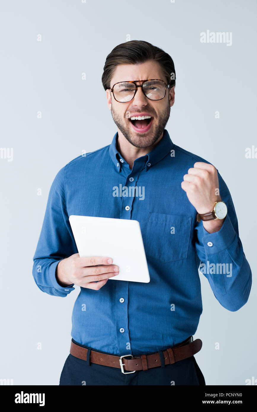 successful young man with tablet celebrating victory isolated on white ...