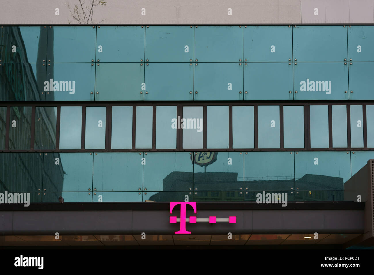 The logo of a Telekom shop on the modern glass facade of a department ...