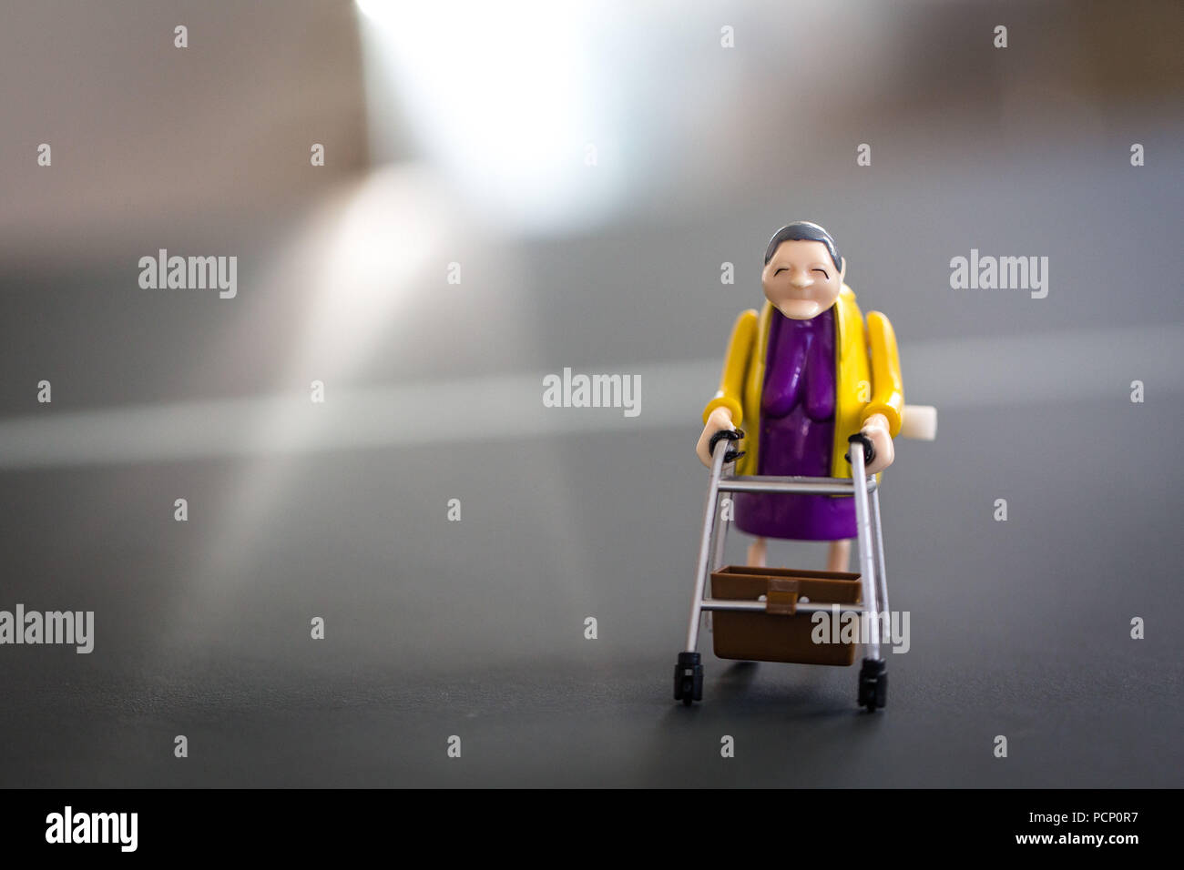 Plastic toy figure, senior woman with walking aid Stock Photo - Alamy