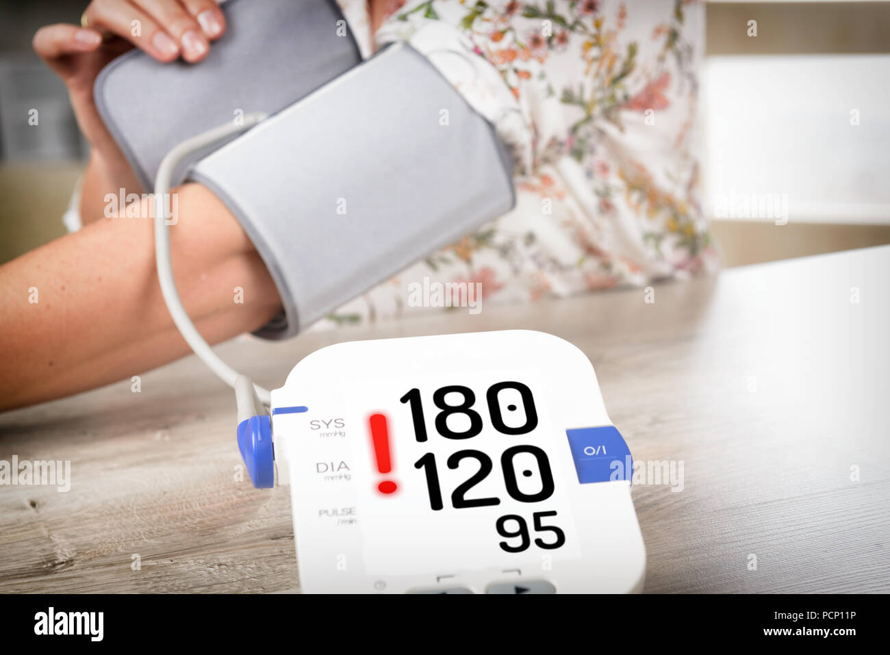 Women's hand with blood pressure monitor cuff. Checking blood pressure ...