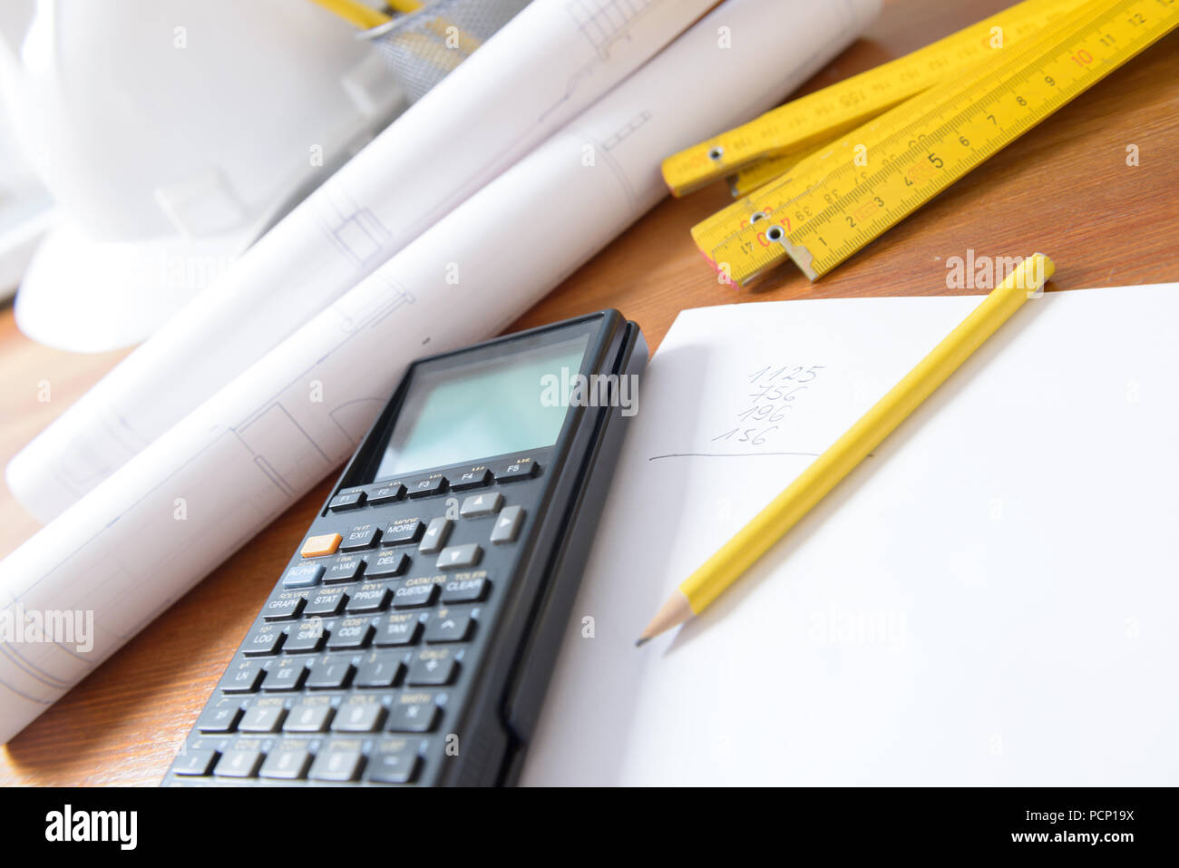 Architect using engineering calculator at his work. Construction plans ...