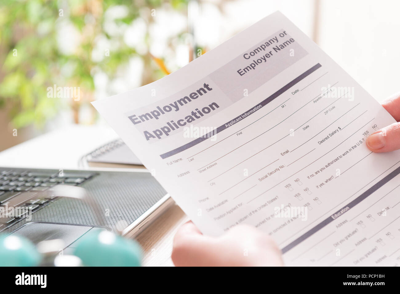 Blank employment application form in hands on a desk Stock Photo - Alamy