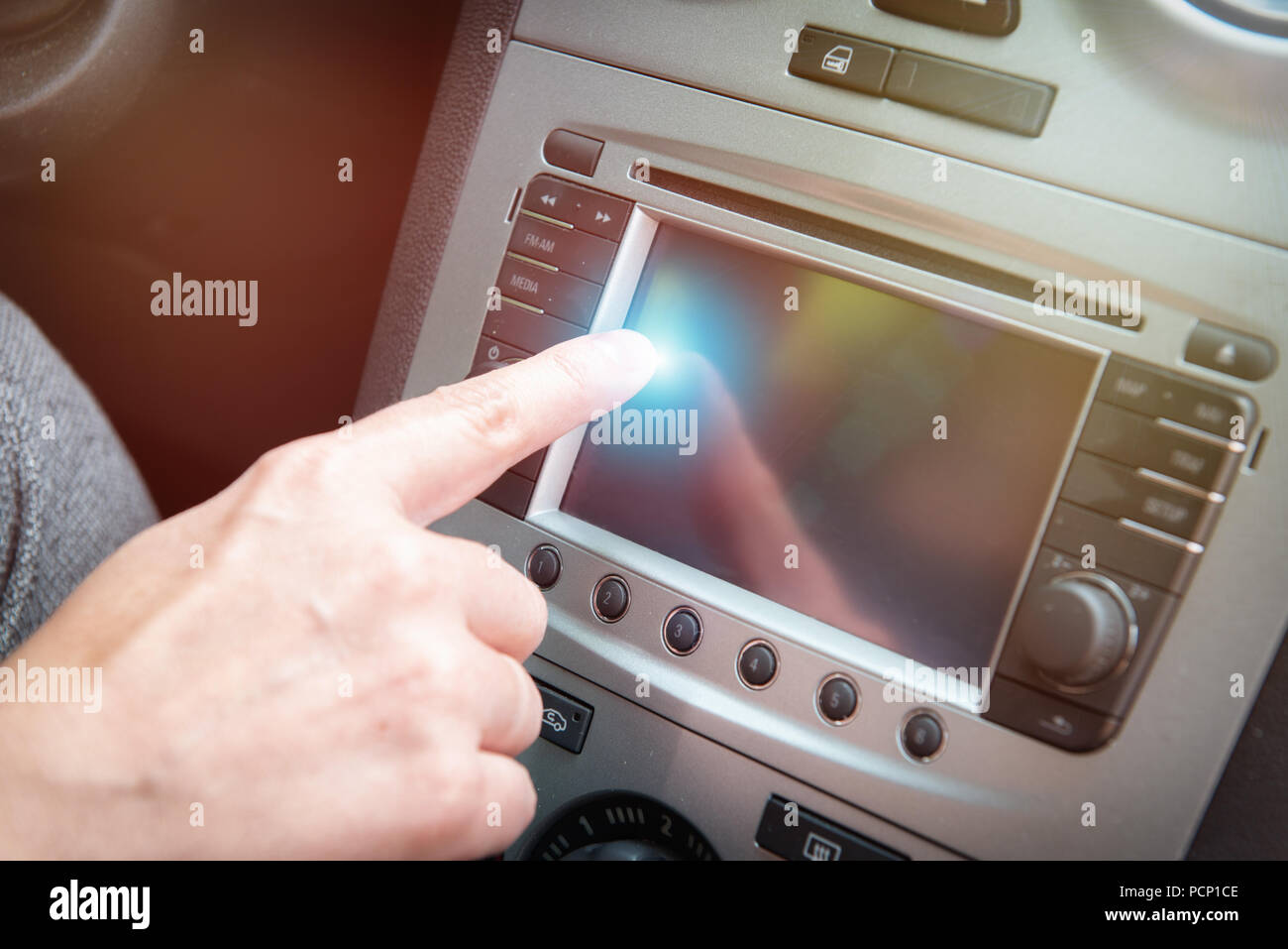 Driver using touchscreen to adjust car navigation or other systems ...