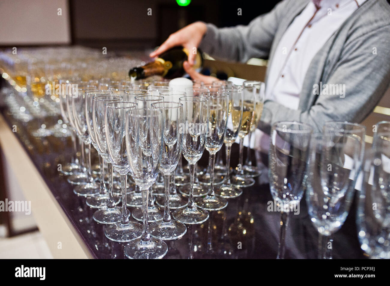 Barman or bartender pours alcohol into glasses in the restaurant Stock ...