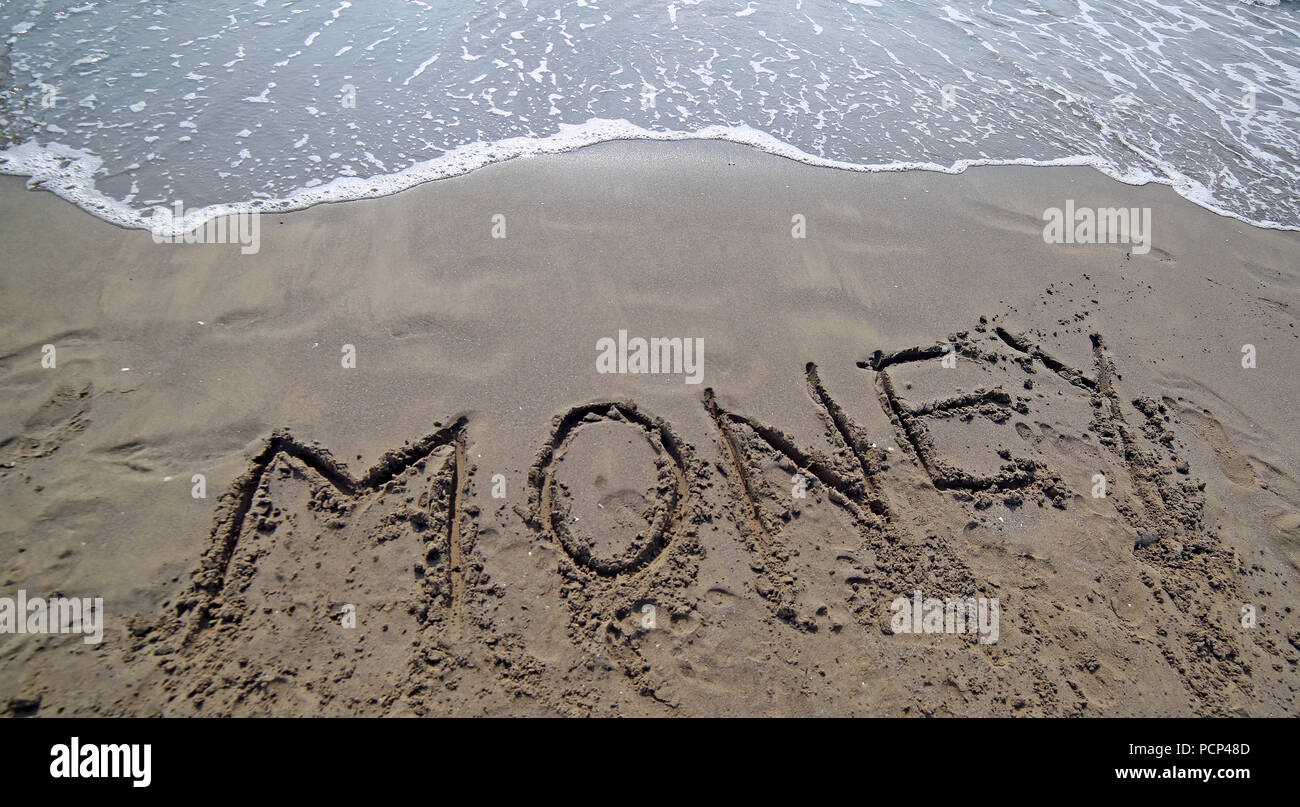 big text MONEY that is deleted by the sea wave on the beach Stock Photo ...