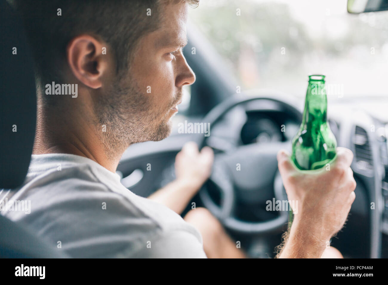 Drunk driver drinking behind the steering wheel of a car Stock Photo ...