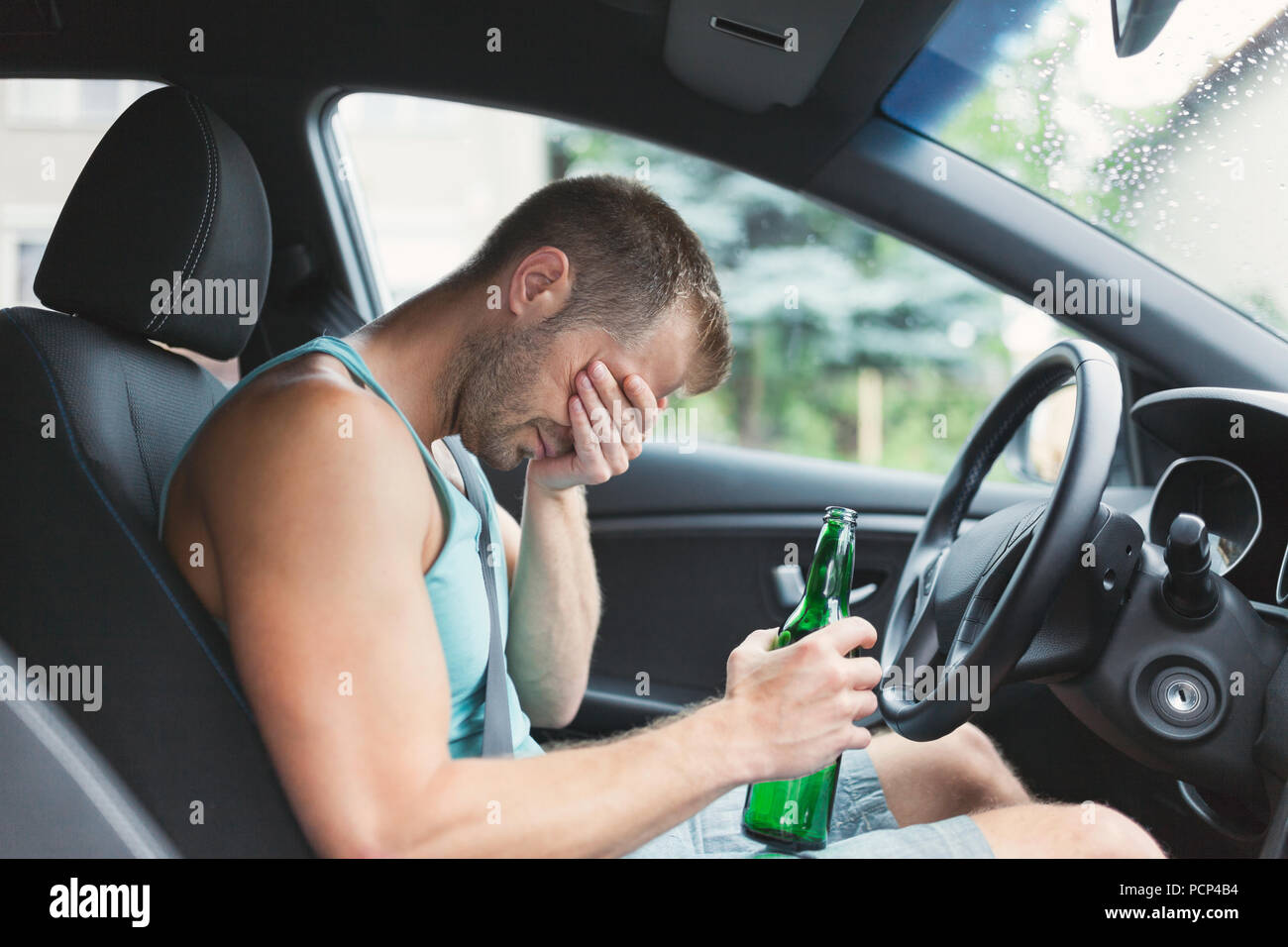 Drunk driver drinking behind the steering wheel of a car Stock Photo ...