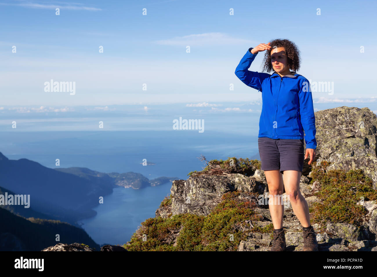 Adventurous woman is enjoying the view in the mountains during a sunny ...