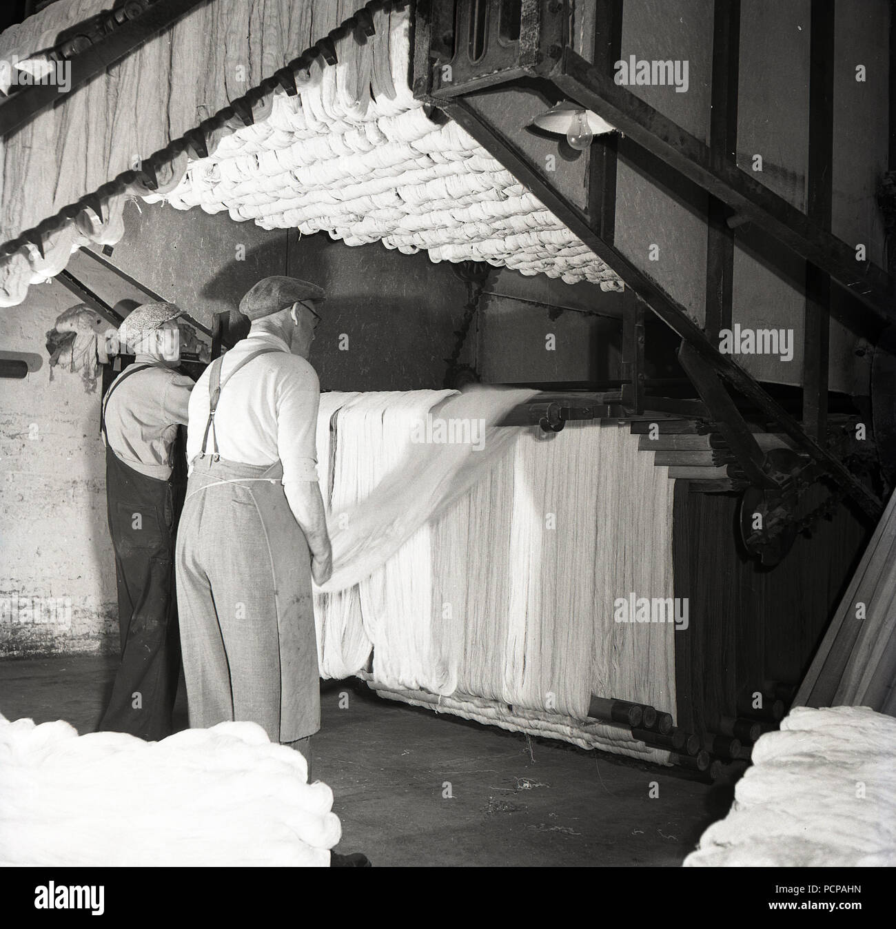 1950s, historical, male mill workers in overalls and wearing caps ...