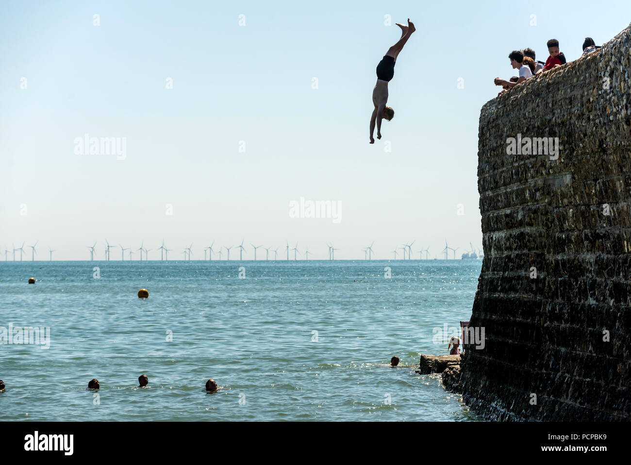 Young people enjoy cooling off at Brighton beach in the late afternoon ...
