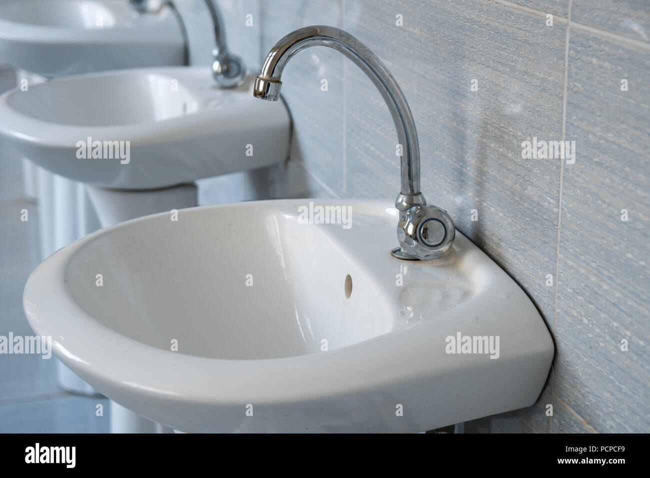 Public water taps in the school's toilet Stock Photo - Alamy