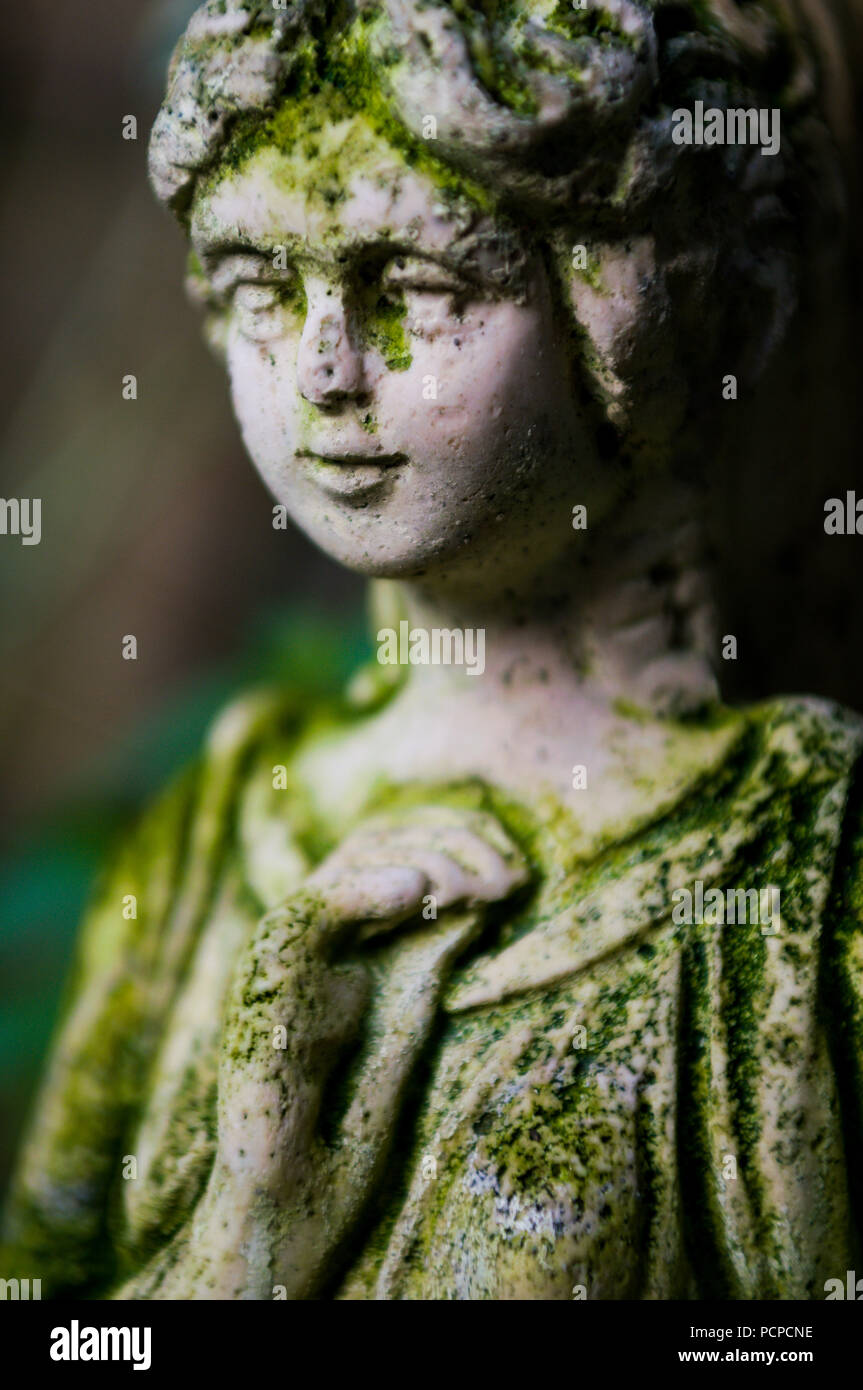 A stone statue of a lady weathered with time Stock Photo - Alamy