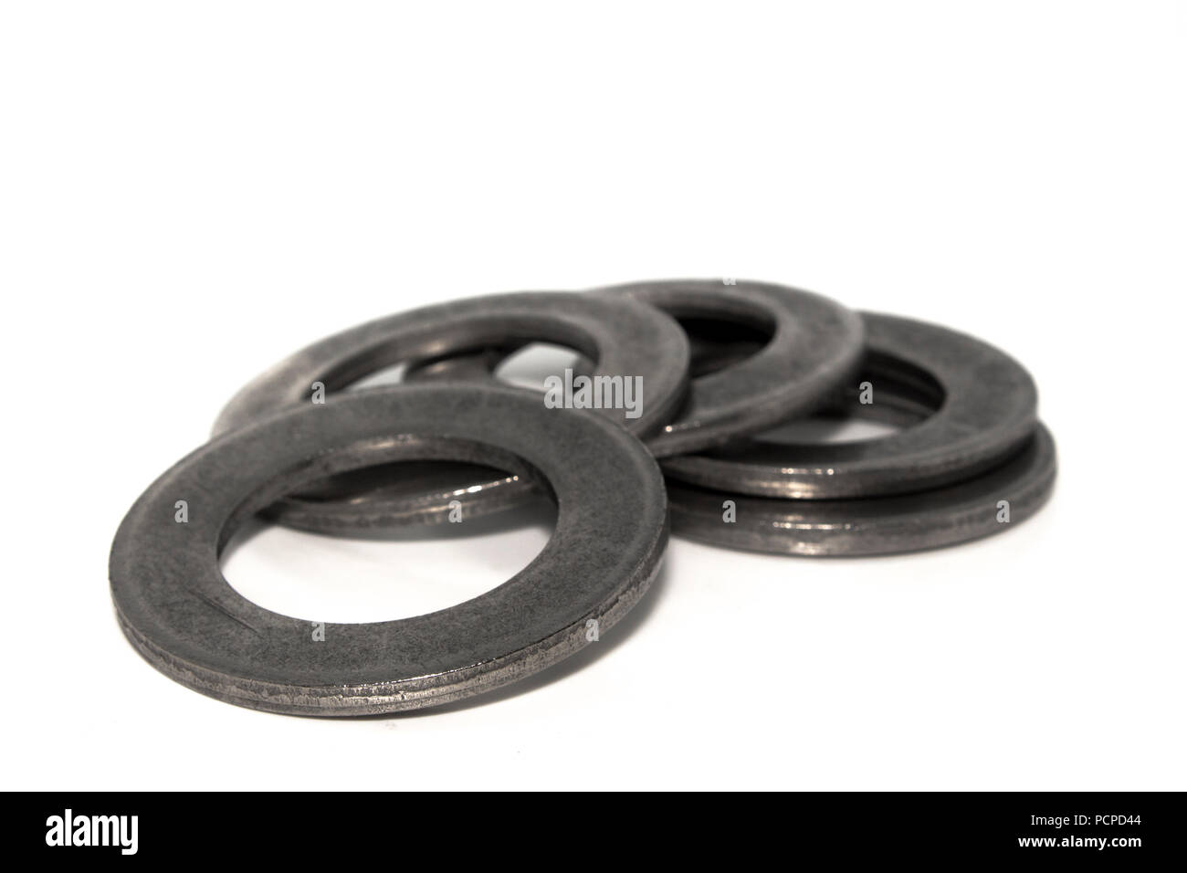 A few big industrial galvanized steel washers on white background Stock ...