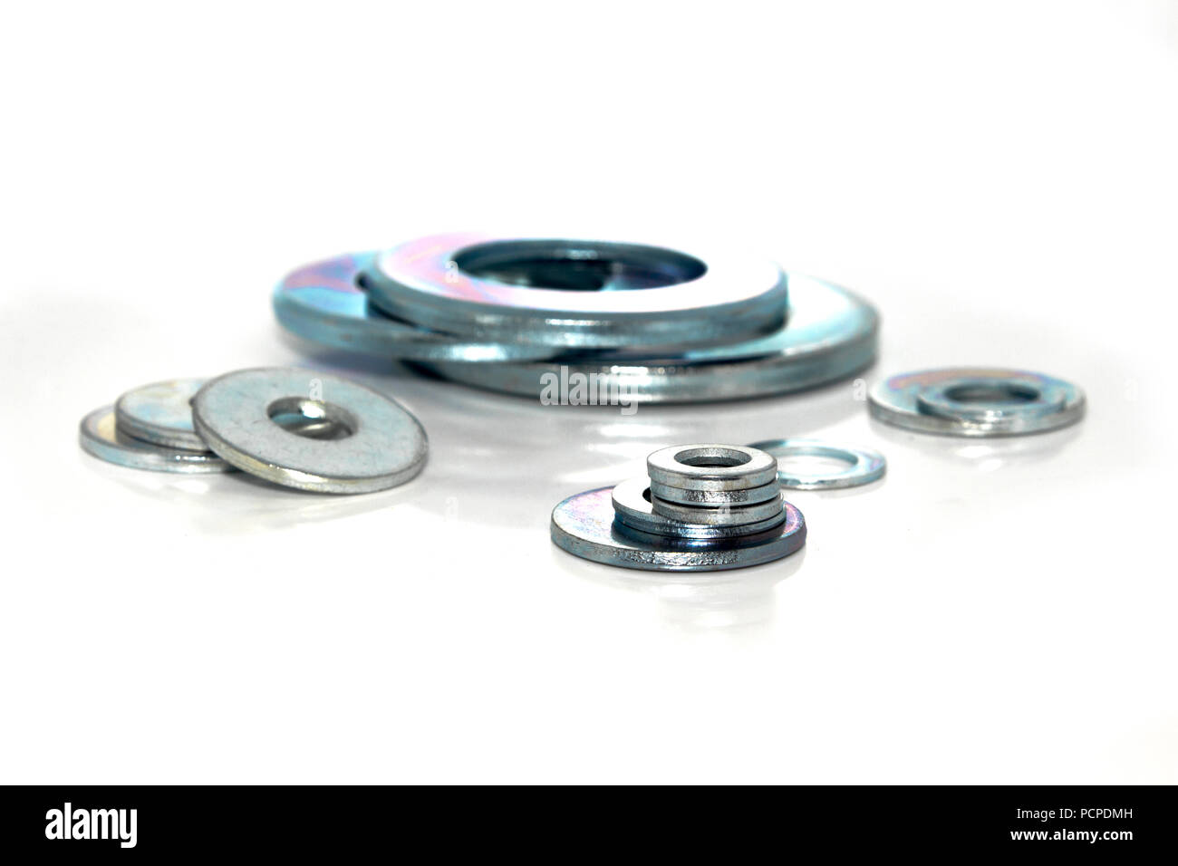 Variety of industrial galvanized steel washers on white background ...
