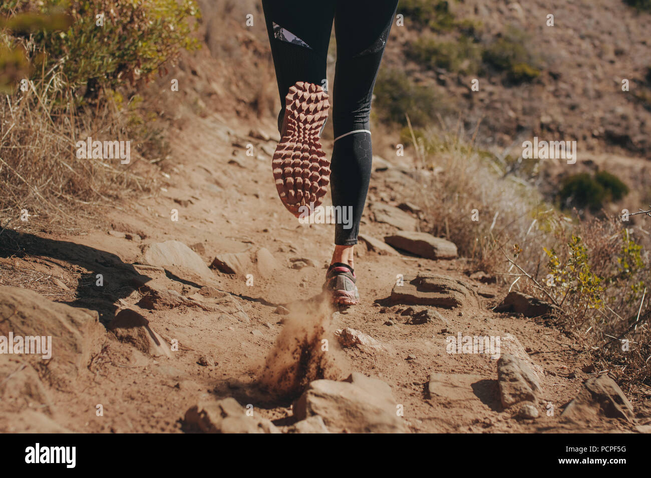 Woman runner legs running on mountain trail. Feet of woman runner ...
