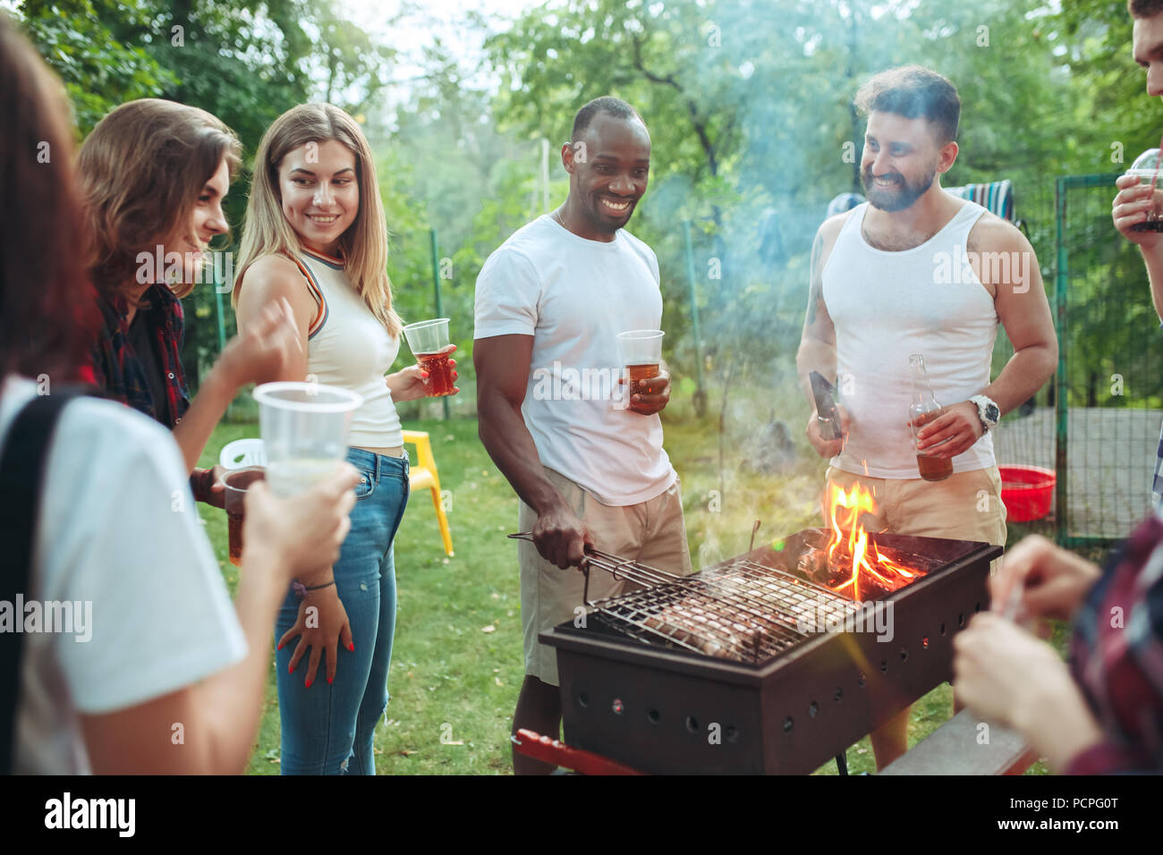 Group of friends making barbecue in the backyard. concept about good ...
