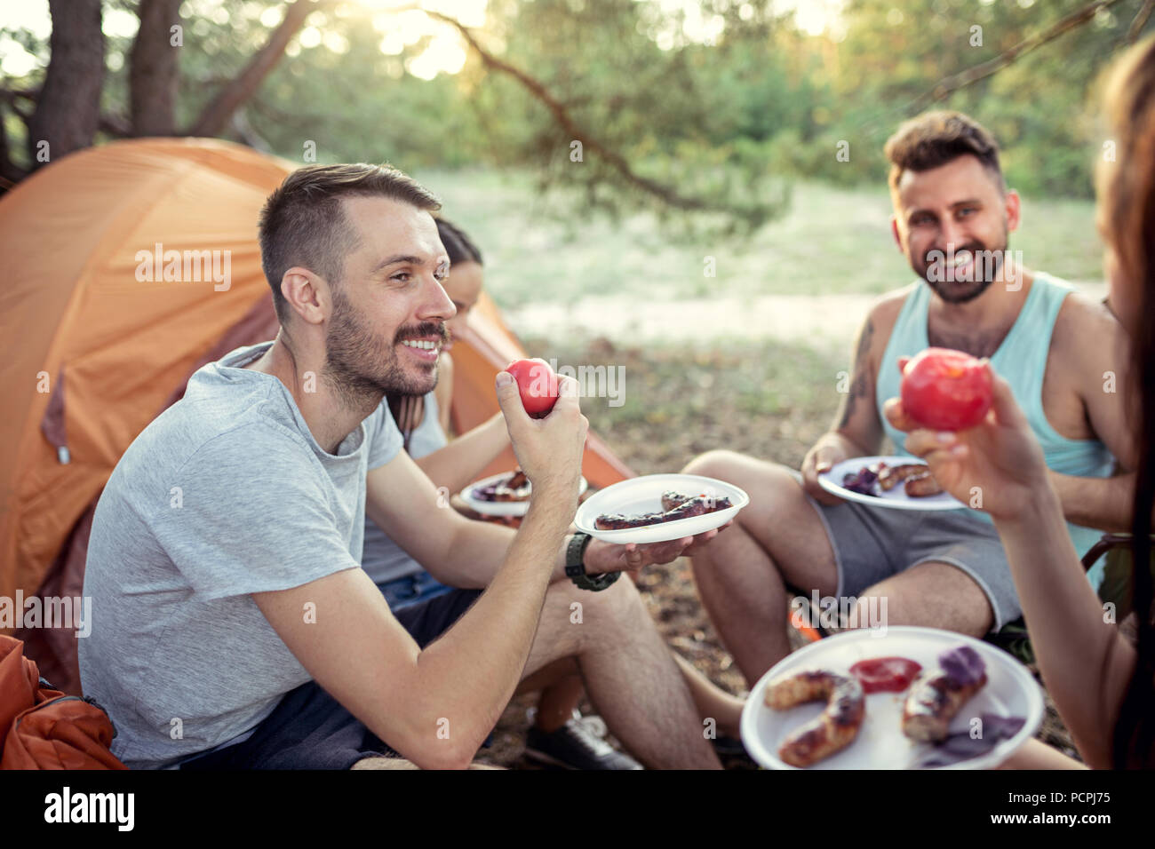 Party, camping of men and women group at forest. They relaxing and ...