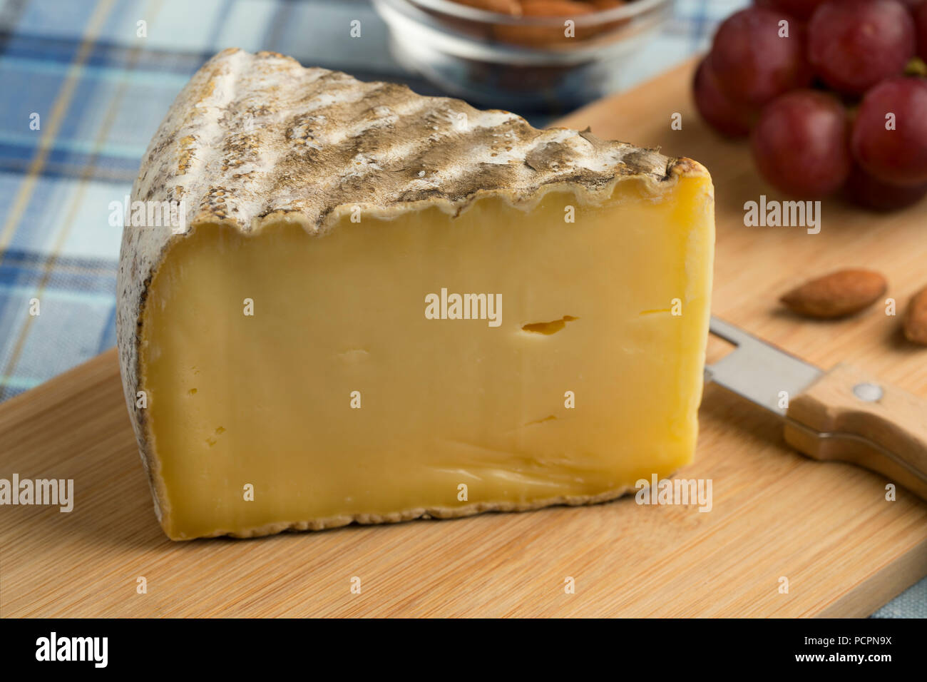 French Tomme de Montagne cheese on a cutting board as dessert Stock ...