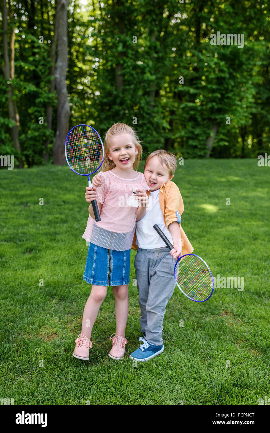 cute happy kids holding badminton rackets and shuttlecock in park Stock ...