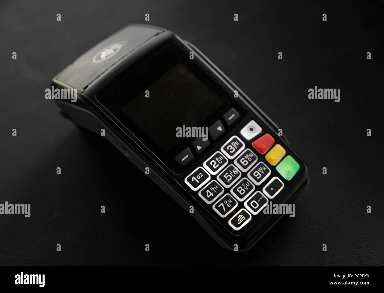 Black POS terminal on a dark table Stock Photo - Alamy