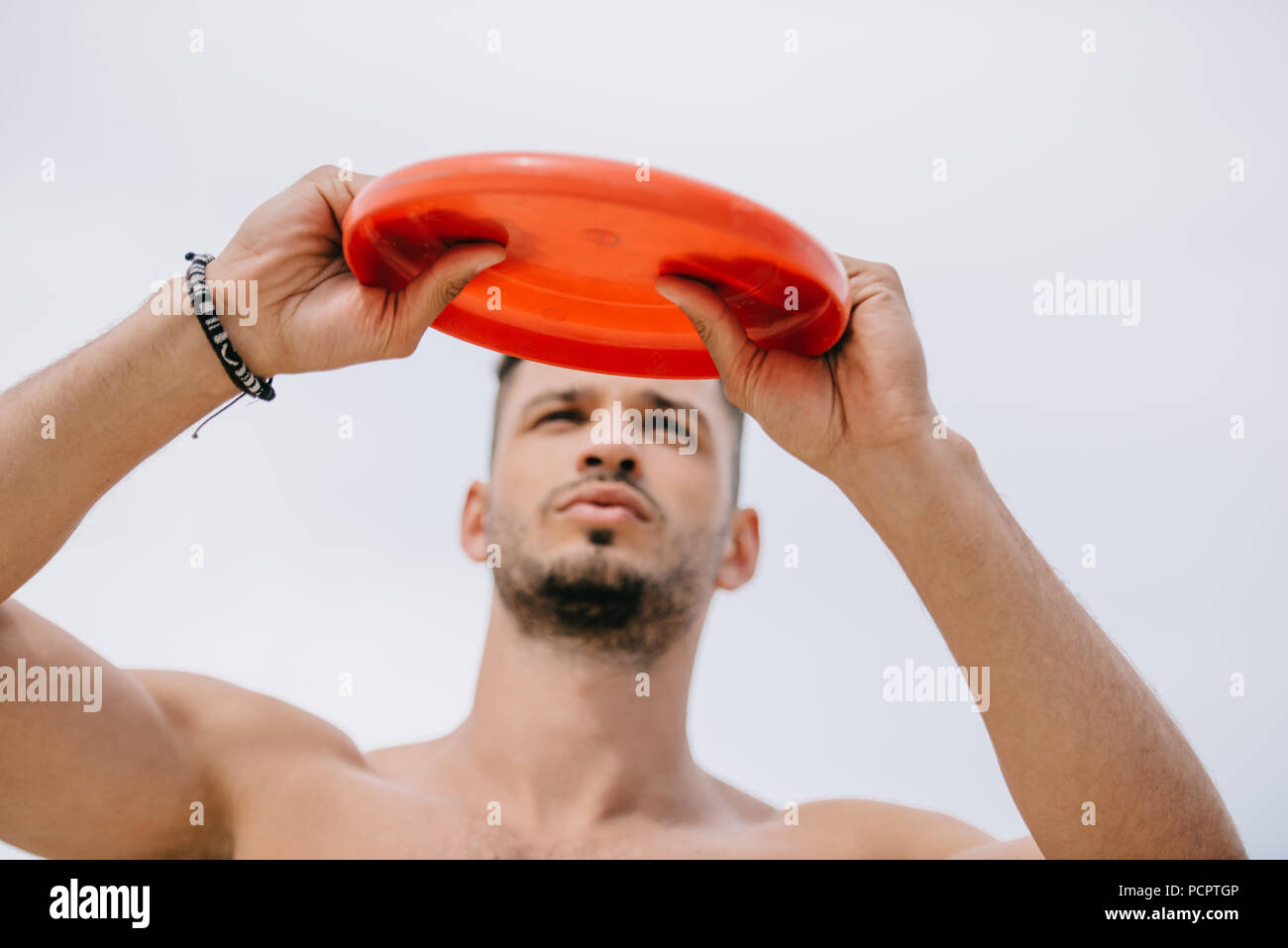 low angle view of handsome young man holding flying disk Stock Photo ...