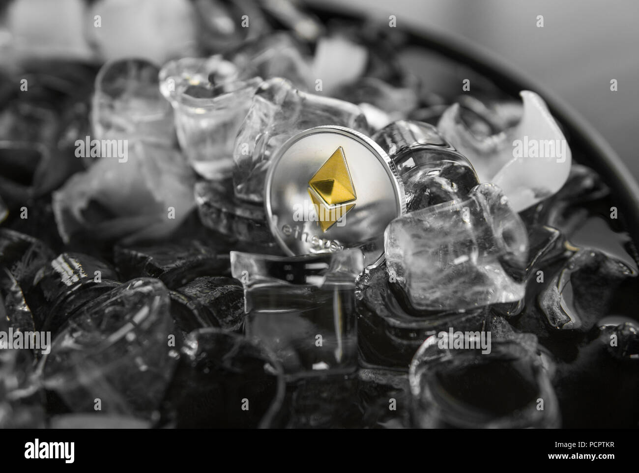 Digital crypto currency physical metal gold Ethereum coin on ice ...
