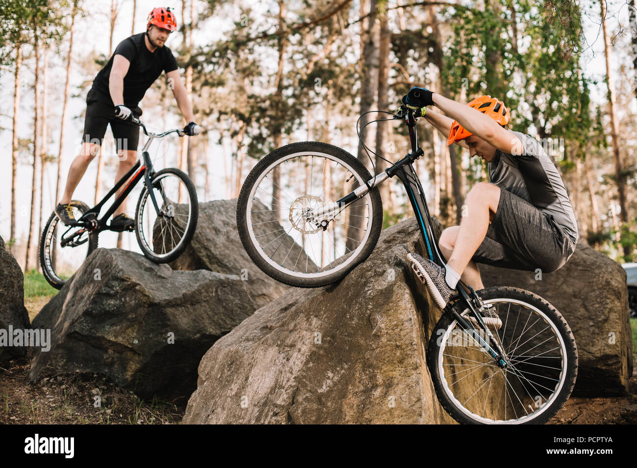 athletic young trial bikers riding on rocks outdoors Stock Photo - Alamy
