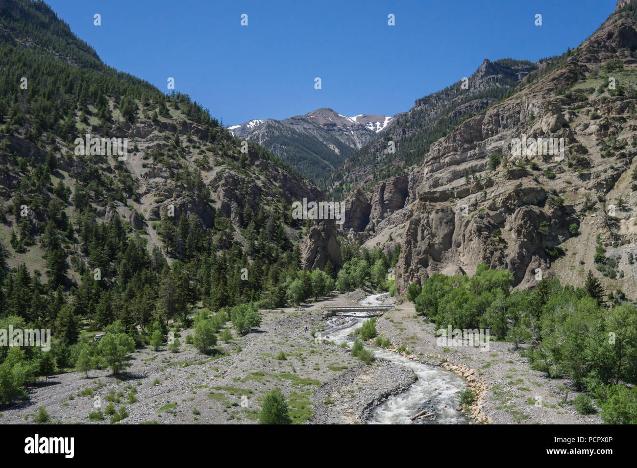 High cliff walls border a rushing river in the wilderness backcountry ...