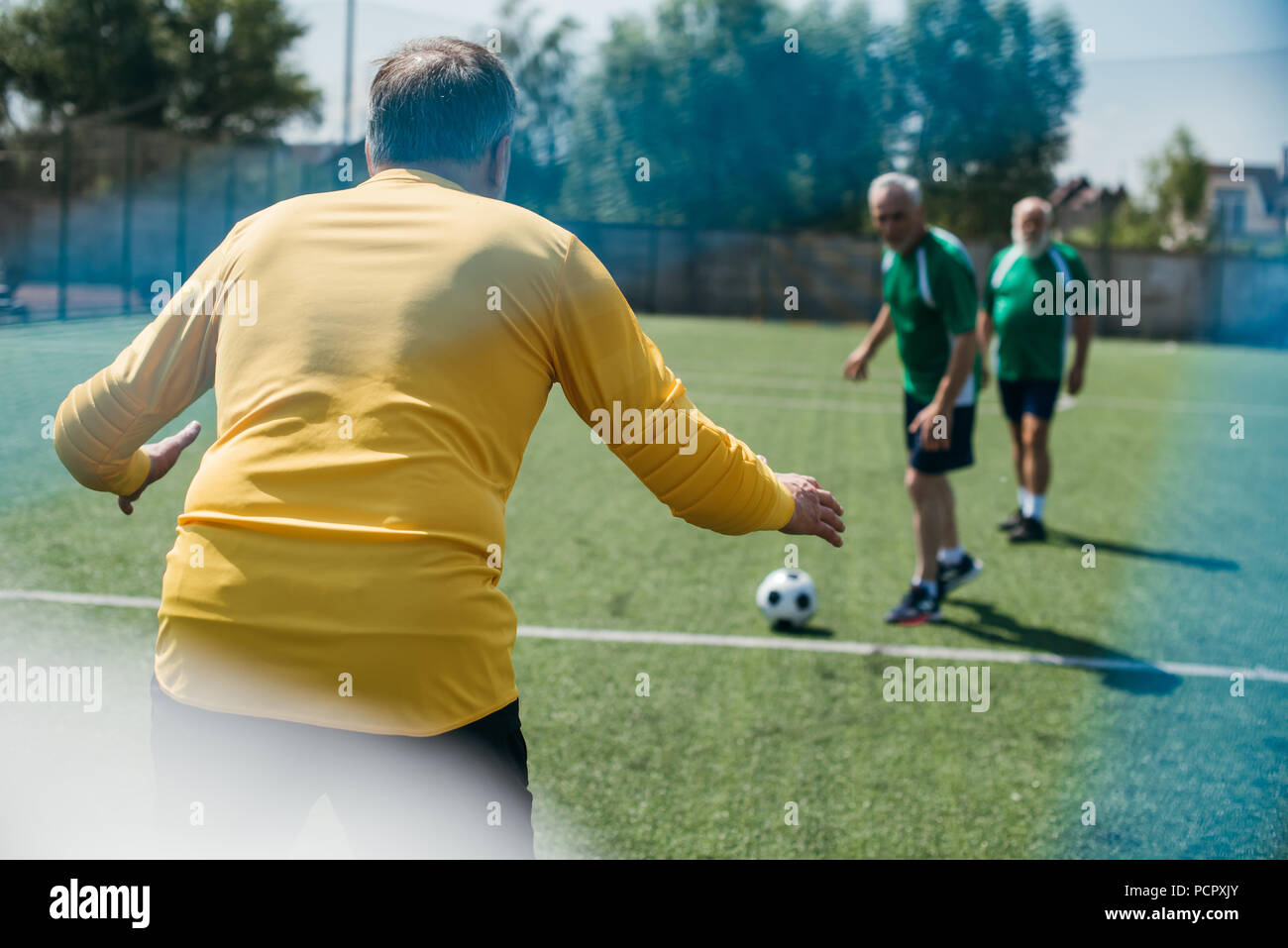 back view of goalkeeper and elderly men on football field Stock Photo ...
