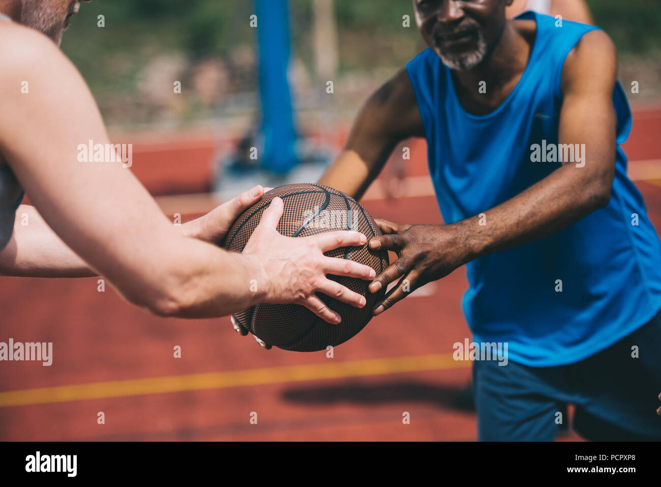 partial view of man giving basketball ball to old african american ...