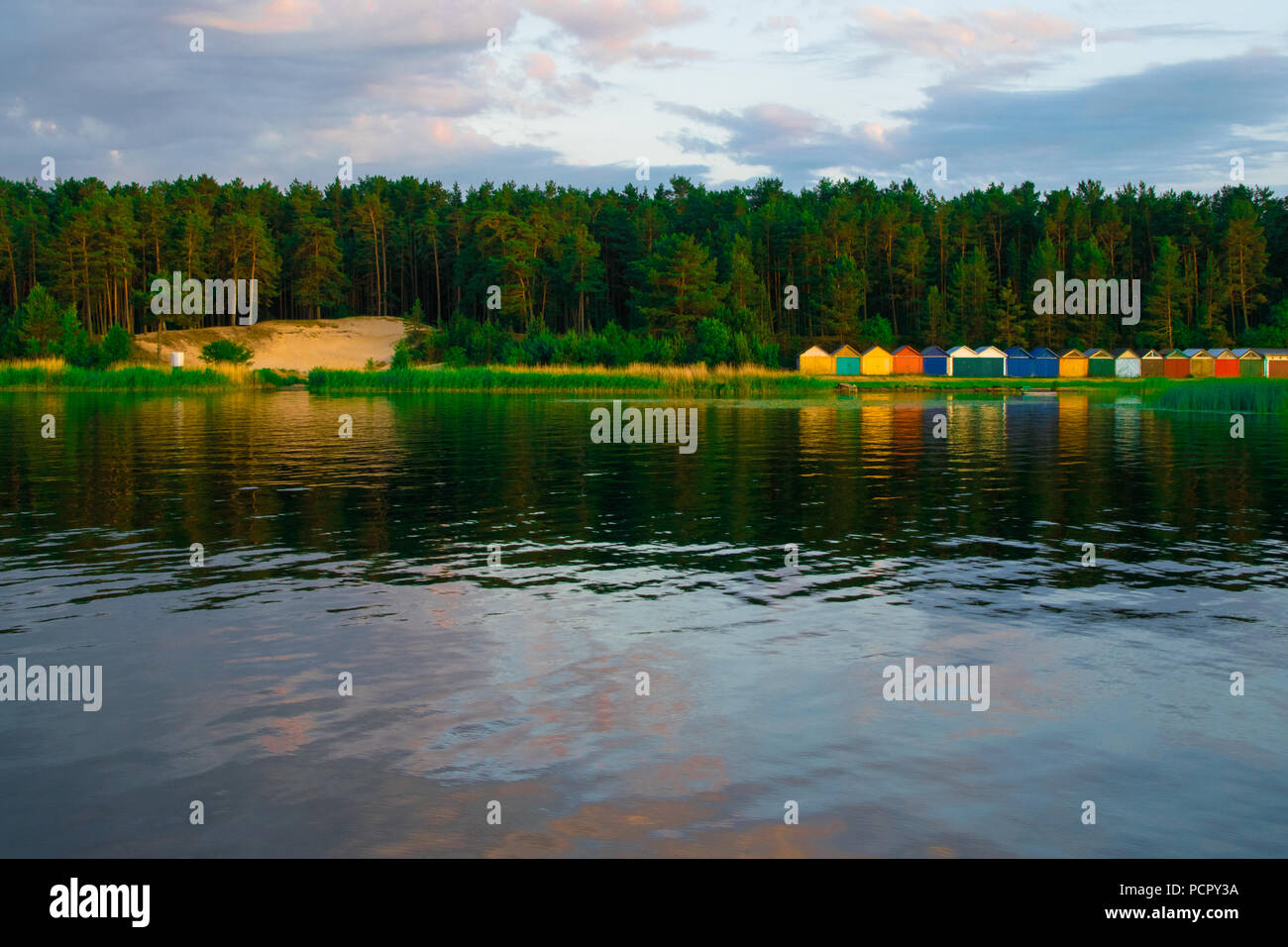 Colorful boat house on the edge of the water. Bright orange, red, green ...