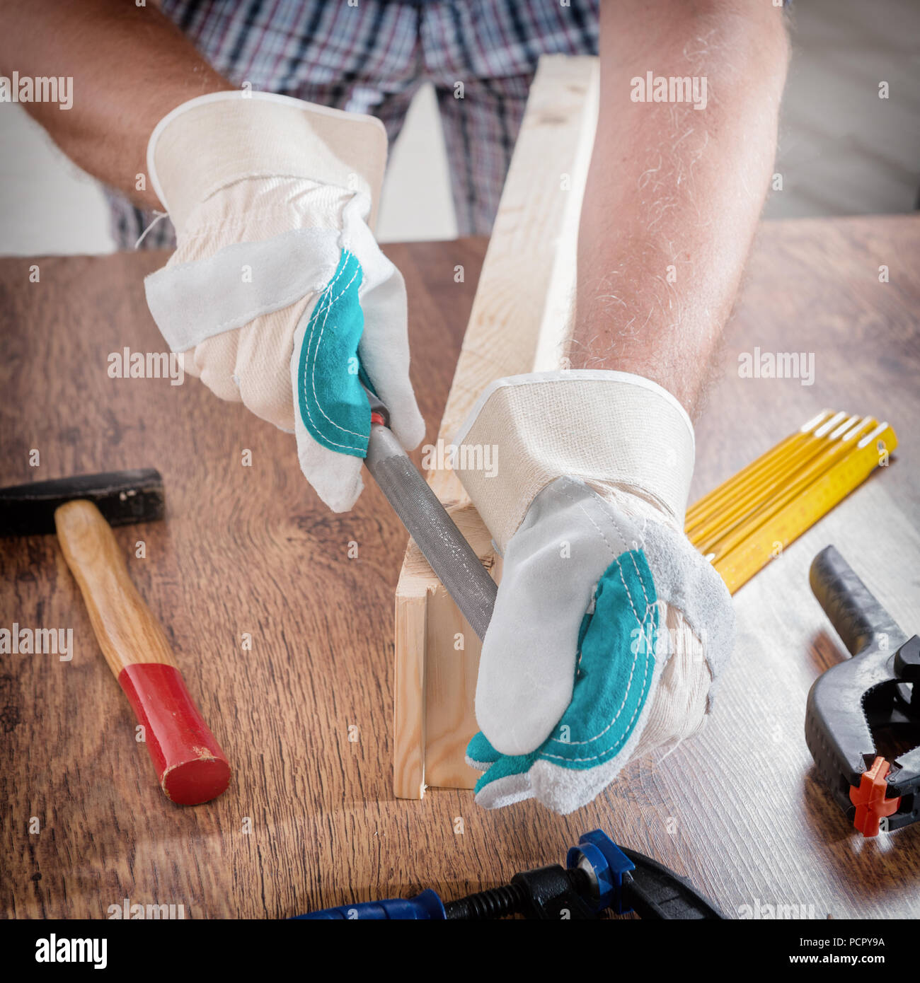 Man sanding a wood with wood file in a workshop Stock Photo - Alamy