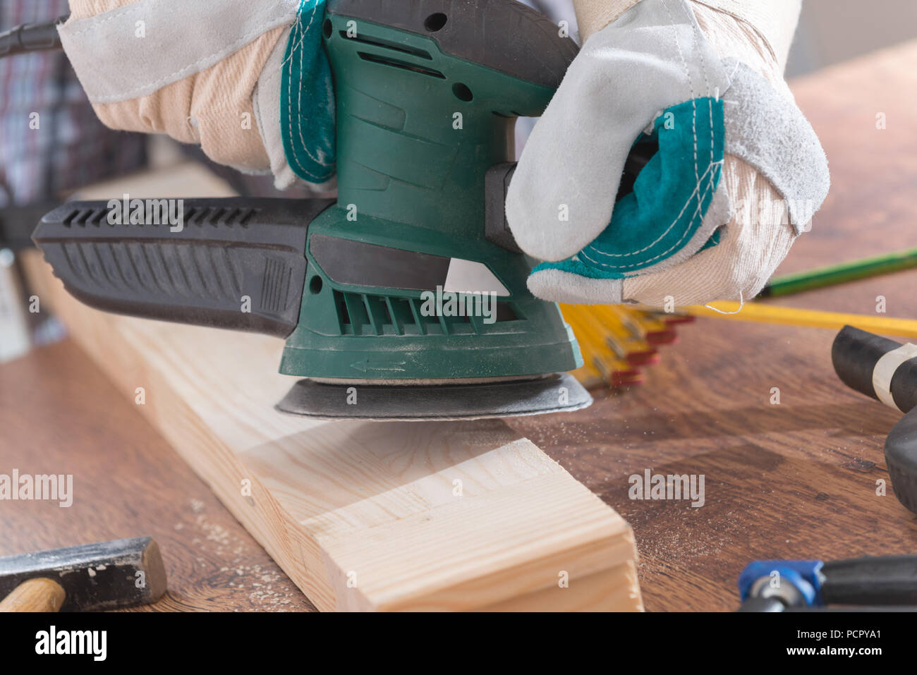Man sanding a wood with orbital sander in a workshop Stock Photo - Alamy