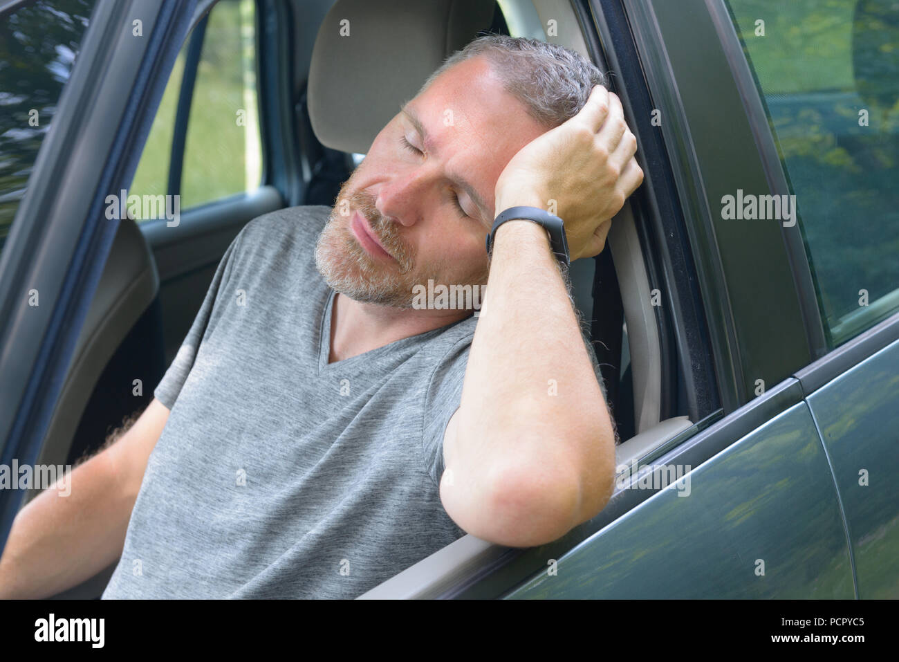Man driver is resting in the car during a travel break Stock Photo - Alamy