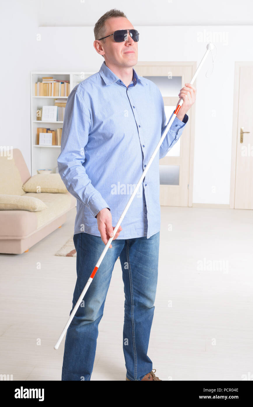 Blind man with white stick and dark glasses at home Stock Photo - Alamy