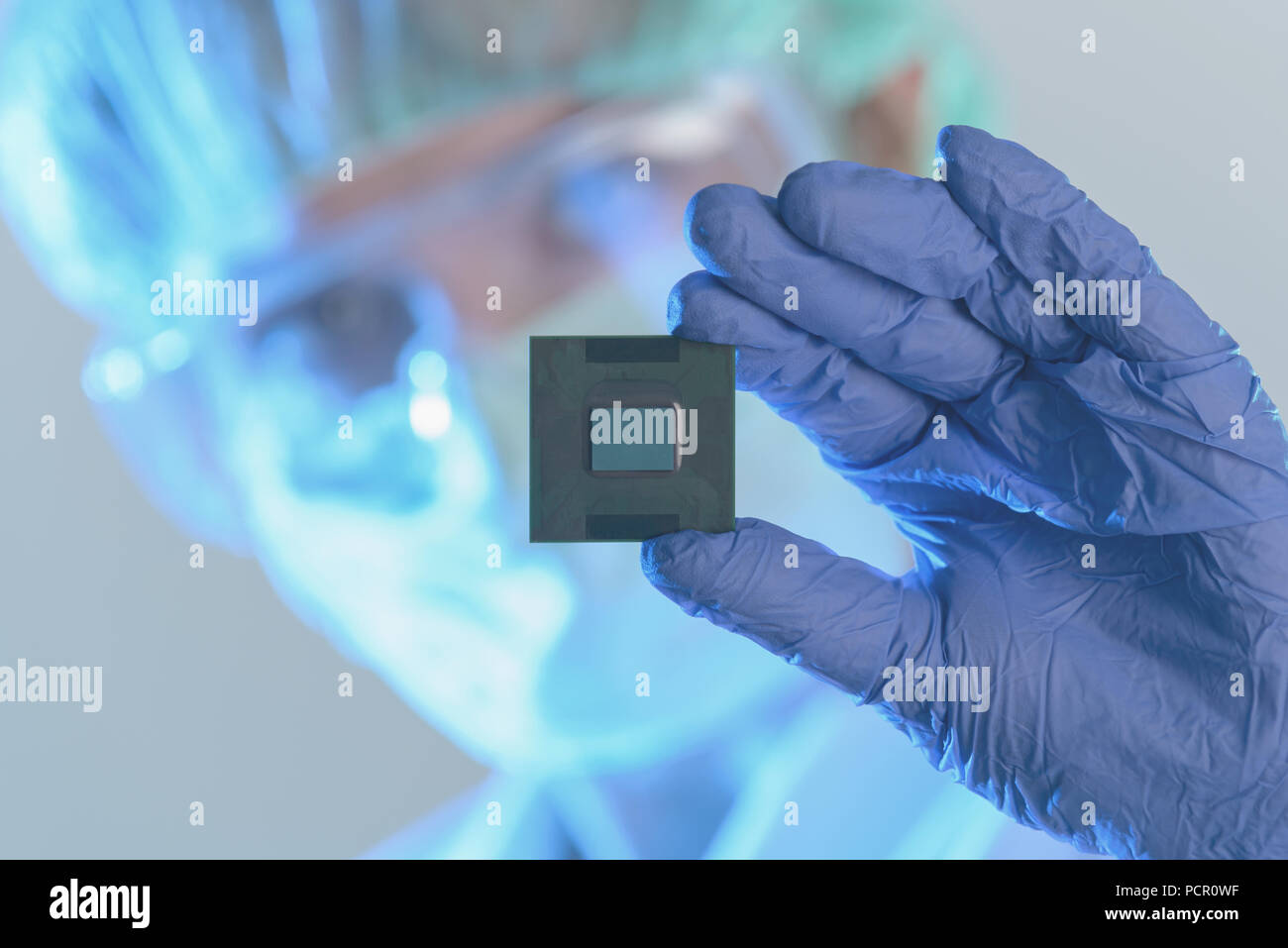 An engineer working in a laboratory wearing a special uniform and ...