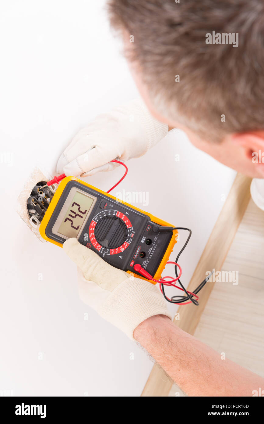 Electrician checking socket voltage with digital multimeter Stock Photo ...