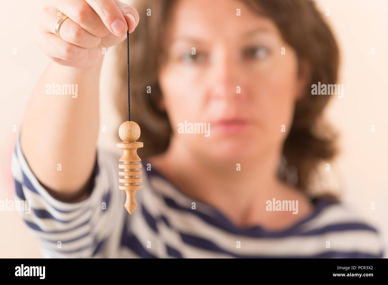 Beautiful woman using pendulum Stock Photo - Alamy