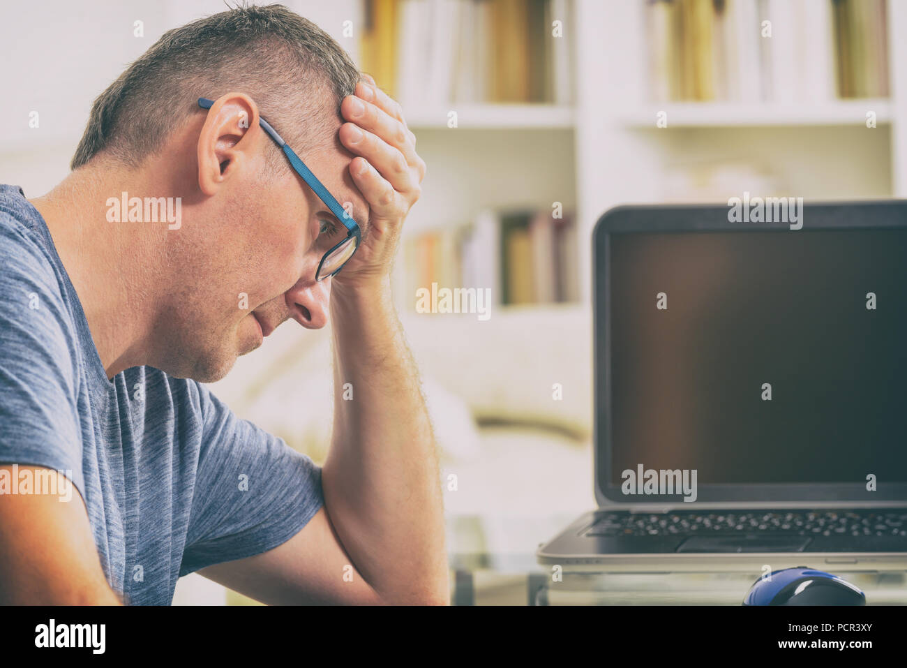 Freelancer man at workplace with headache holding his head on hands ...