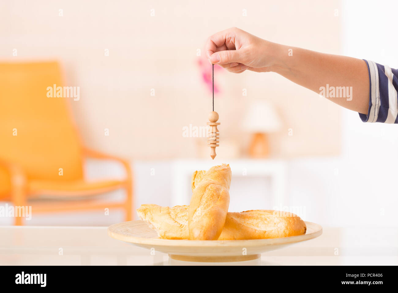 Hand with pendulum dowsing over food to check its quality Stock Photo ...