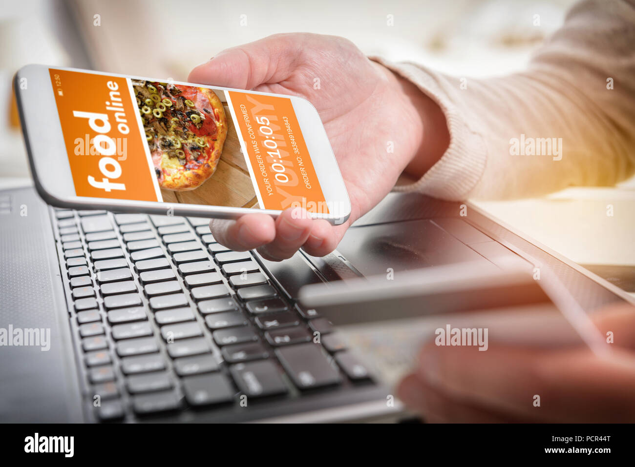 Ordering food online. Smartphone in hand and credit card in other ...