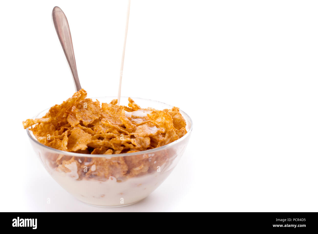 milk pouring onto cornflakes isolated on white Stock Photo - Alamy